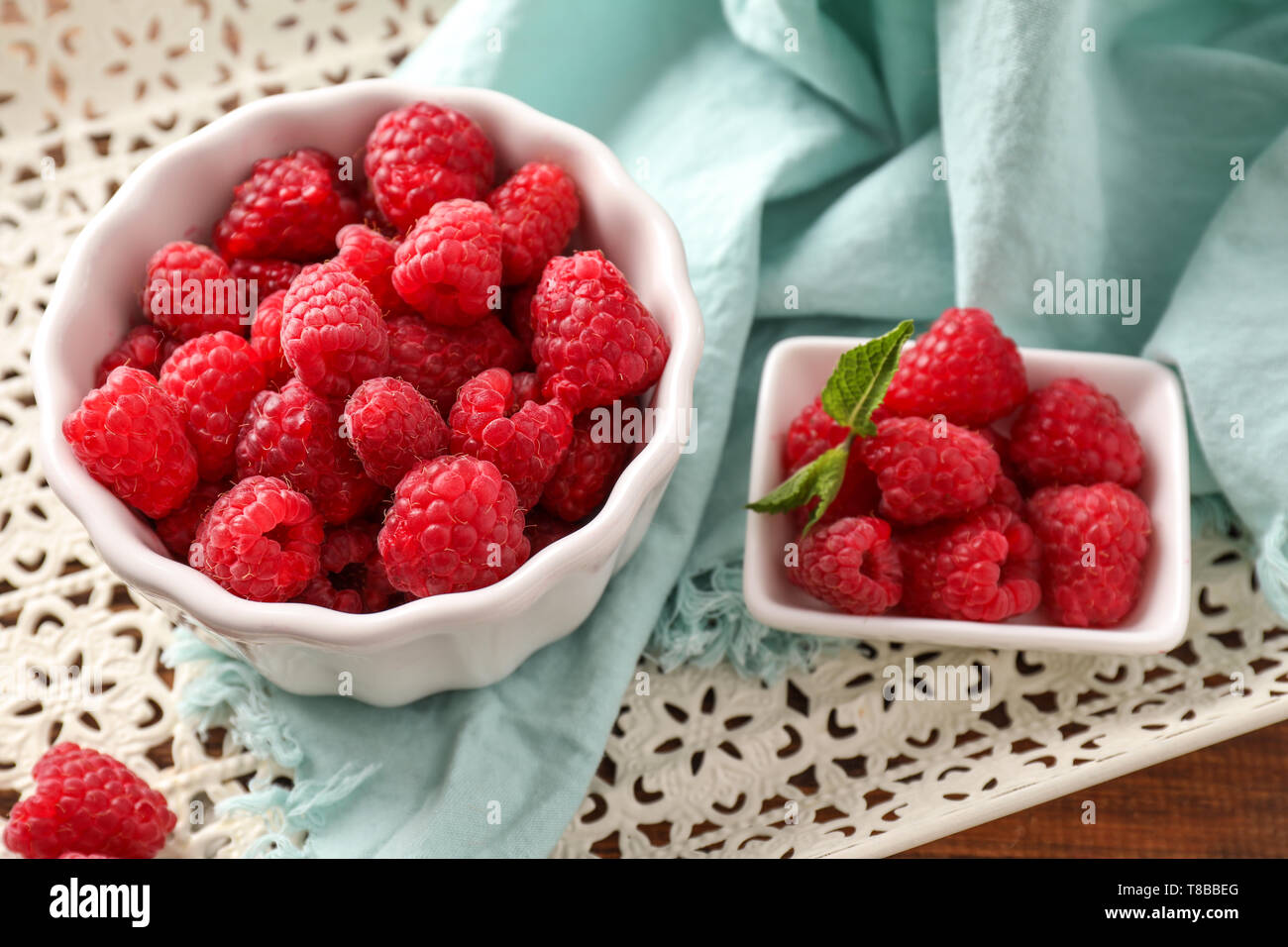 Bowls with sweet ripe raspberries on table Stock Photo - Alamy