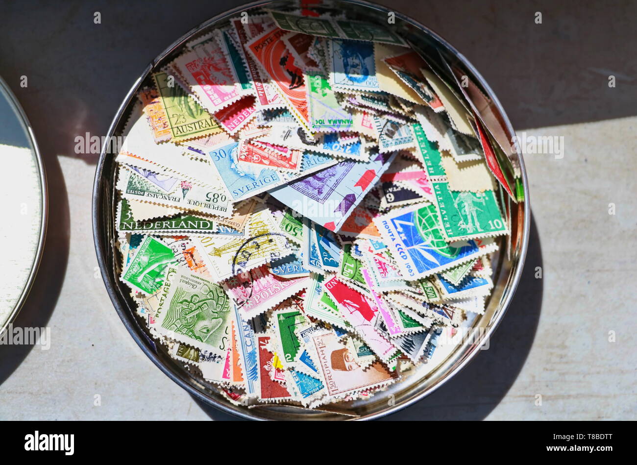 multicolored stamps in a tin Stock Photo - Alamy