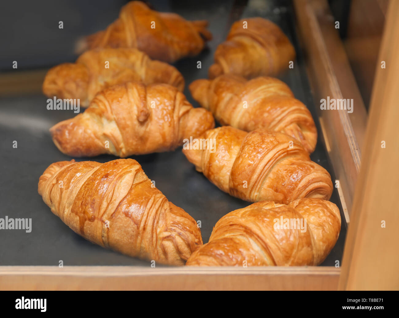 Fresh croissants in bakery shop, view through glass Stock Photo - Alamy