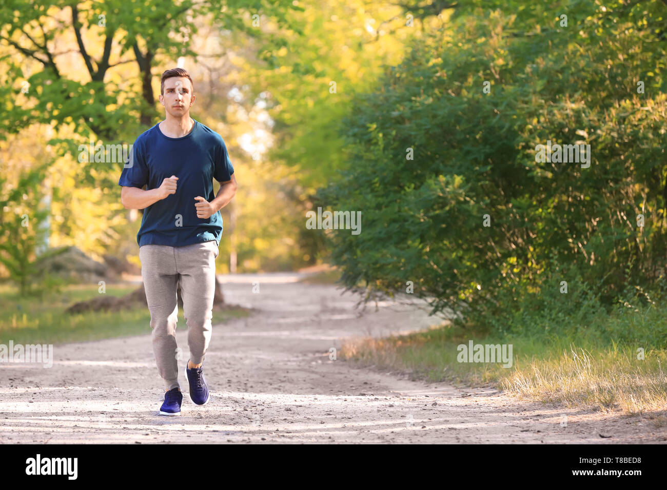 Sporty young man running in park Stock Photo - Alamy