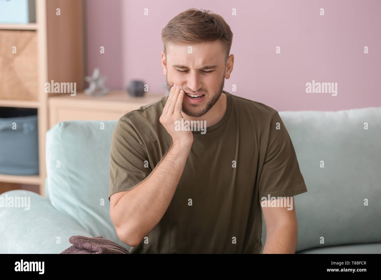 Young man suffering from toothache at home Stock Photo - Alamy