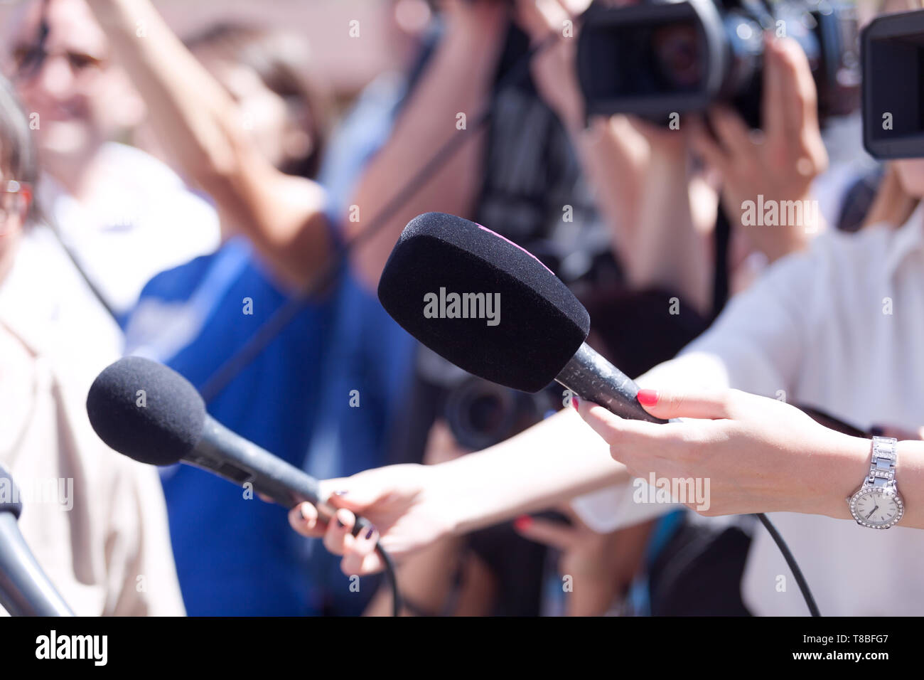 Reporter holding microphone conducting press interview Stock Photo - Alamy