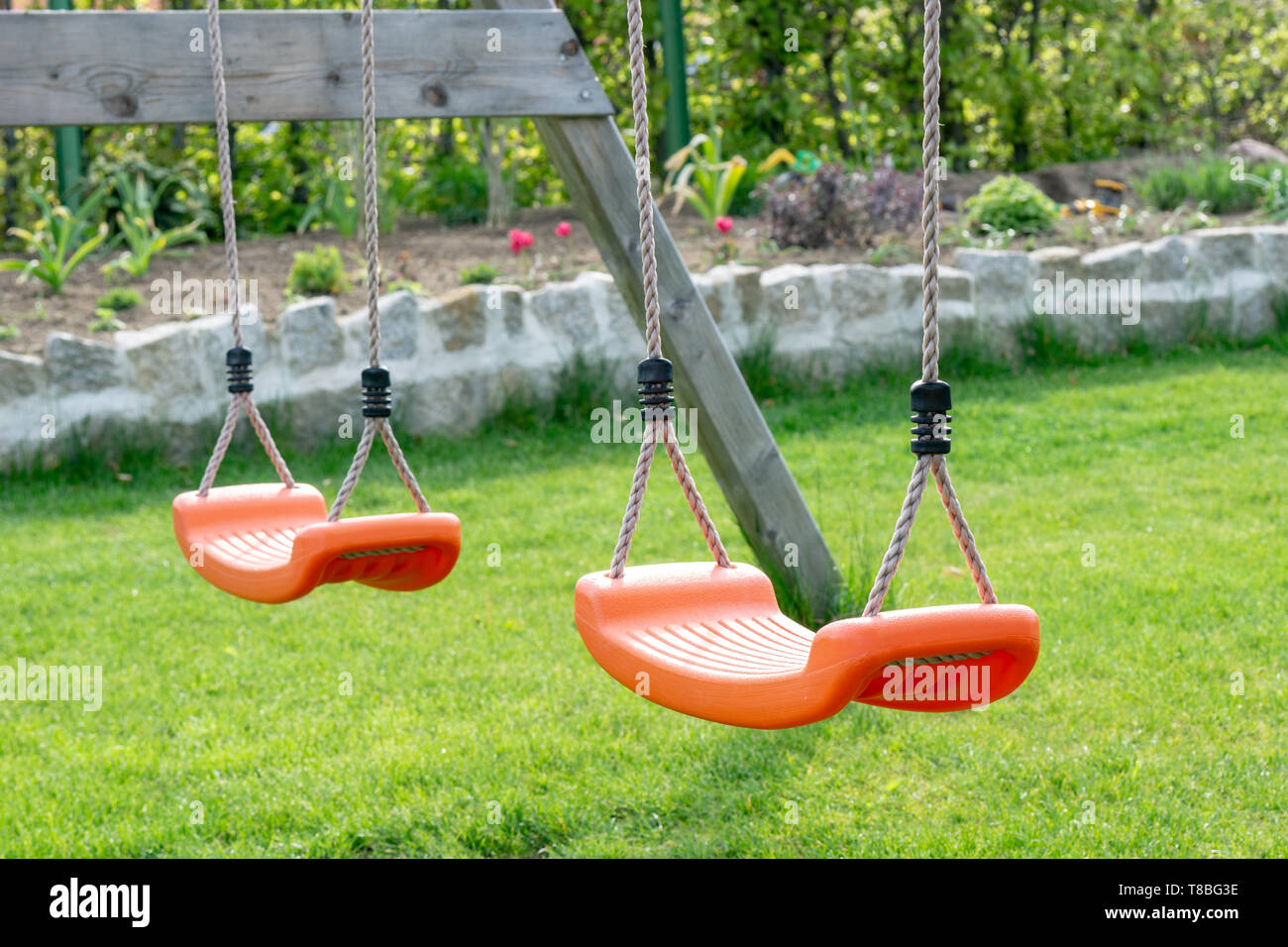 orange swings in the garden - playground for children Stock Photo - Alamy