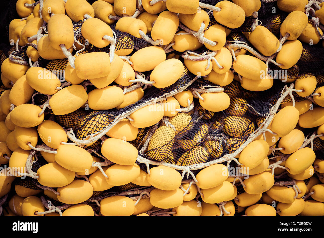 Yellow fishing nets with weathered buoys Stock Photo - Alamy