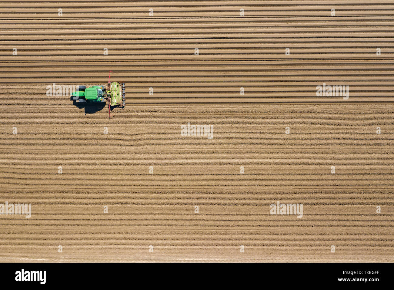 Aerial view of farming tractor plowing and spraying on field ...