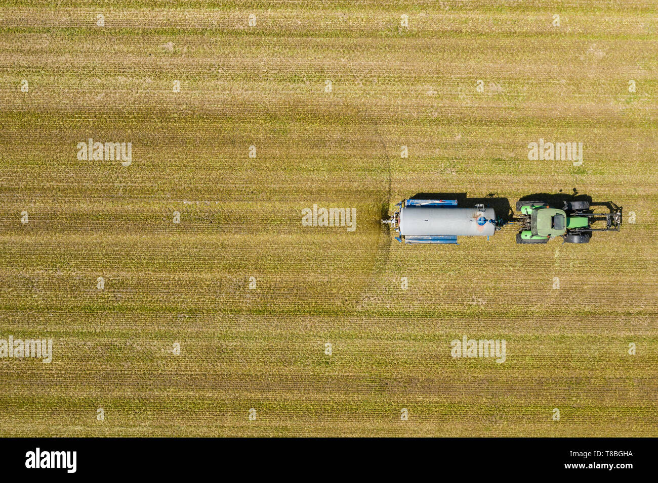 Aerial view of farming tractor plowing and spraying on field ...