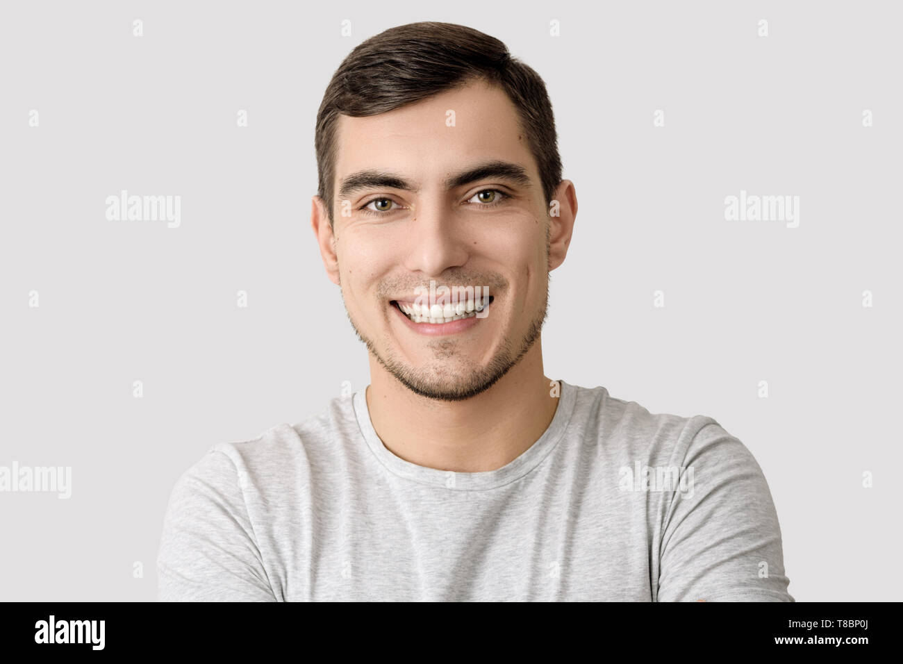 portrait of smiling man in a gray t-shirt on a light background for ...