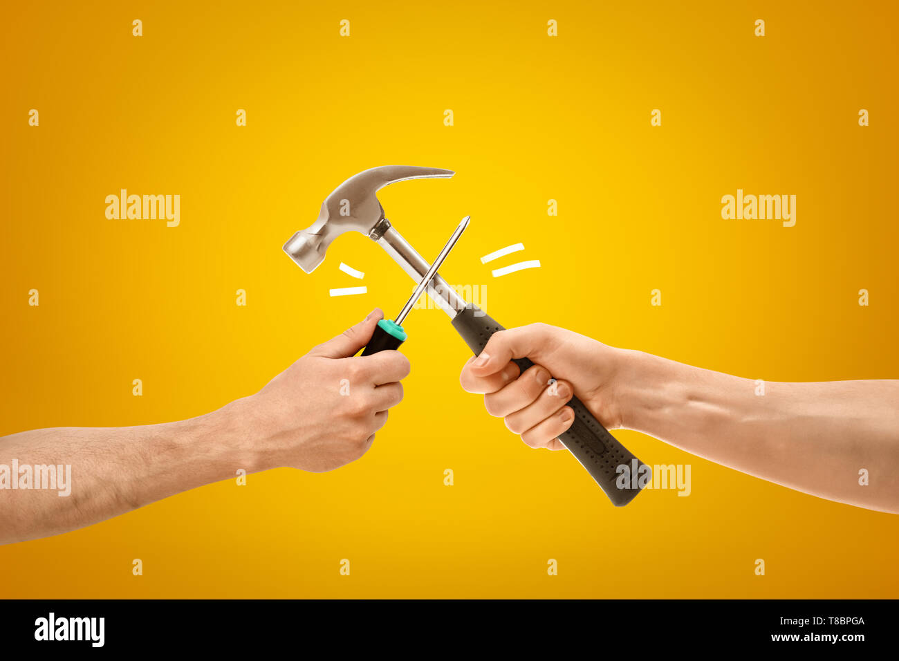 Hand holding screwdriver fighting with hand holding hammer on yellow ...