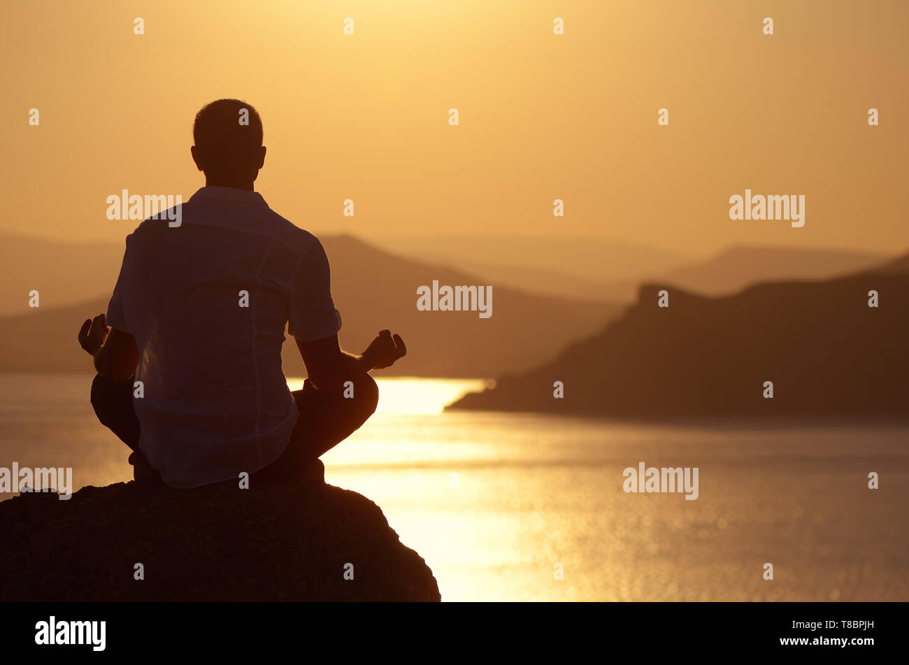 Meditating guy on a mountain hi-res stock photography and images - Alamy