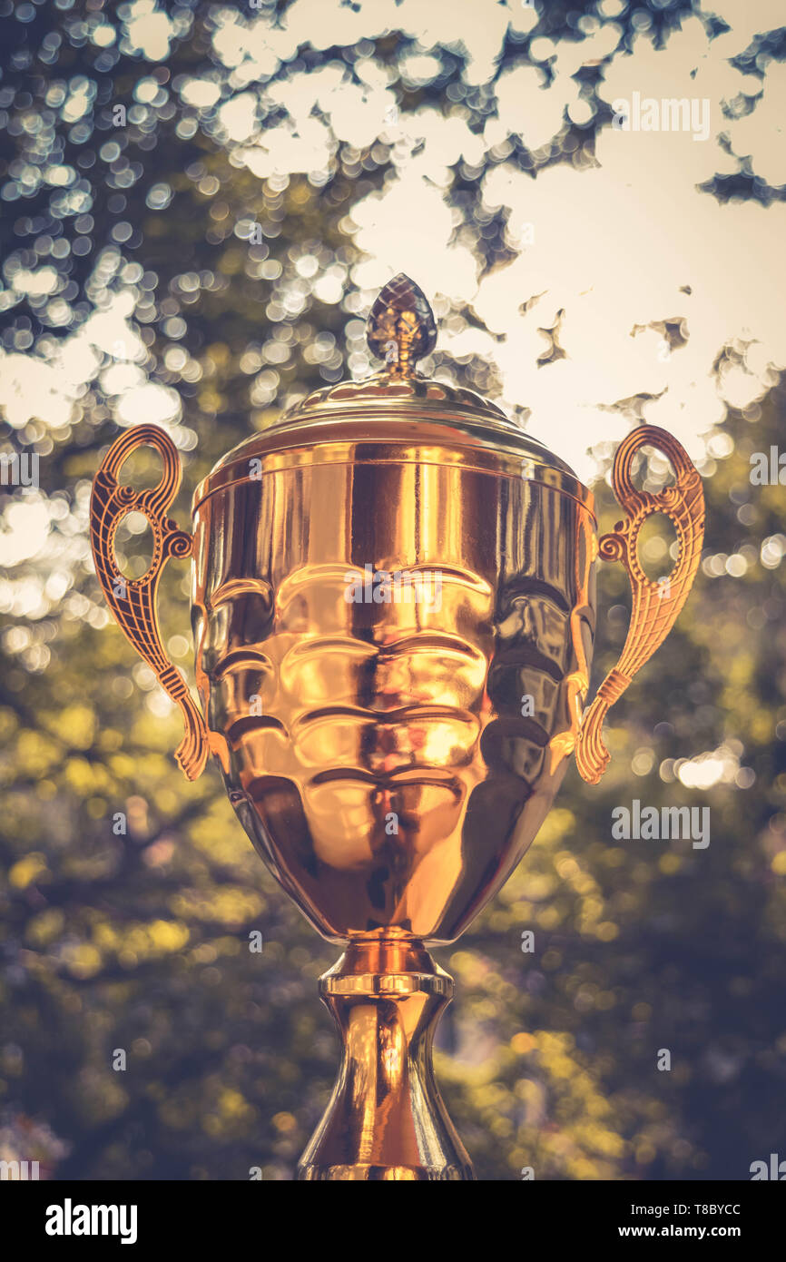 Gold trophy on green nature background Stock Photo - Alamy