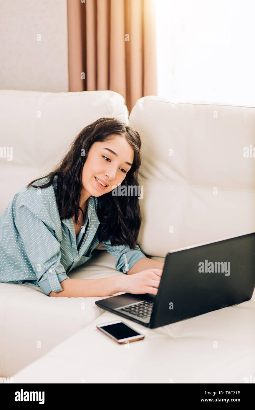 Indoor shot of student girl using black laptop for doing homework ...