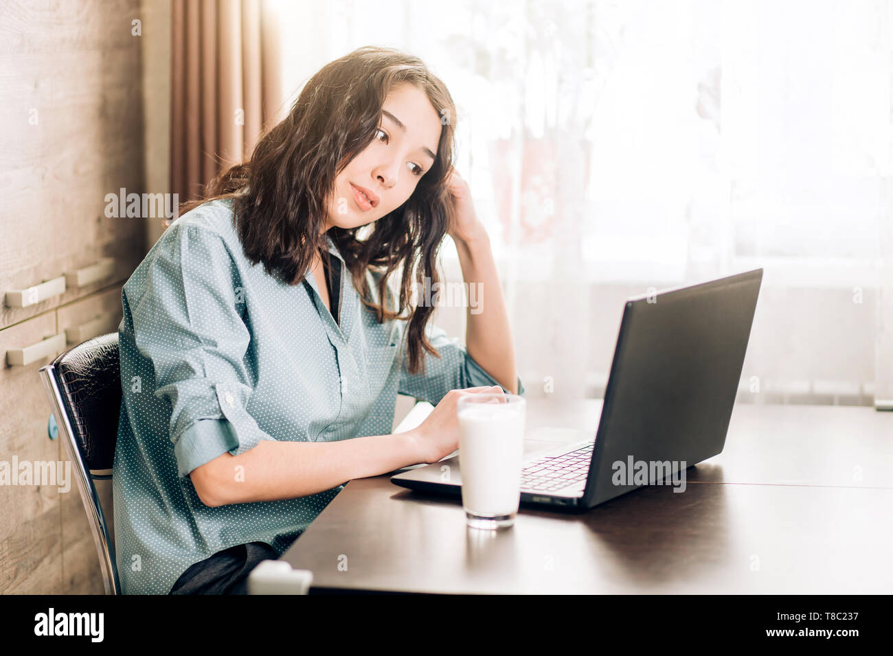 Hard-working girl looking concentrated at screen of computer, working ...