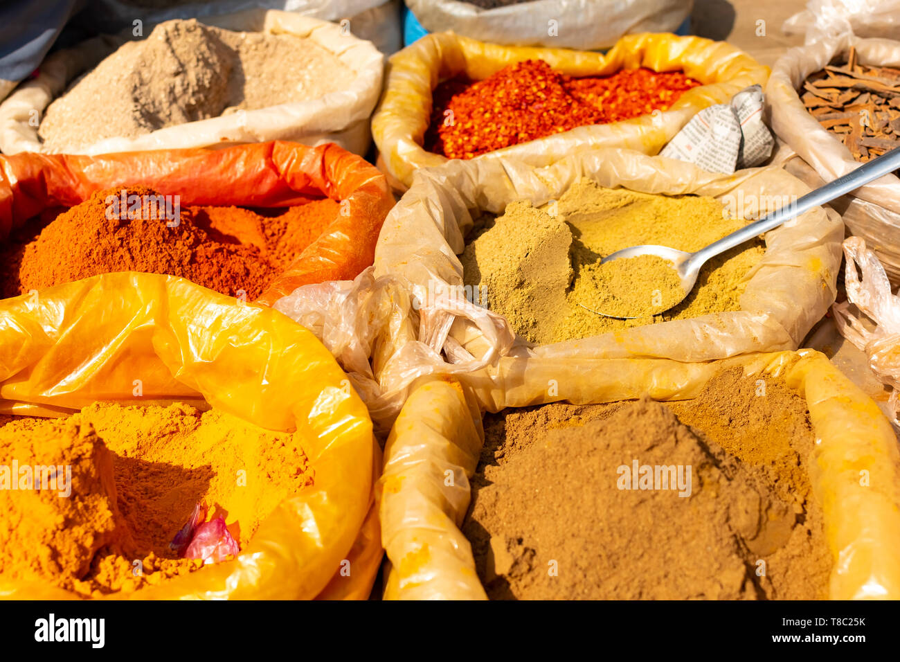 Colorful curry a pepper spices powders and herbs in traditional street ...