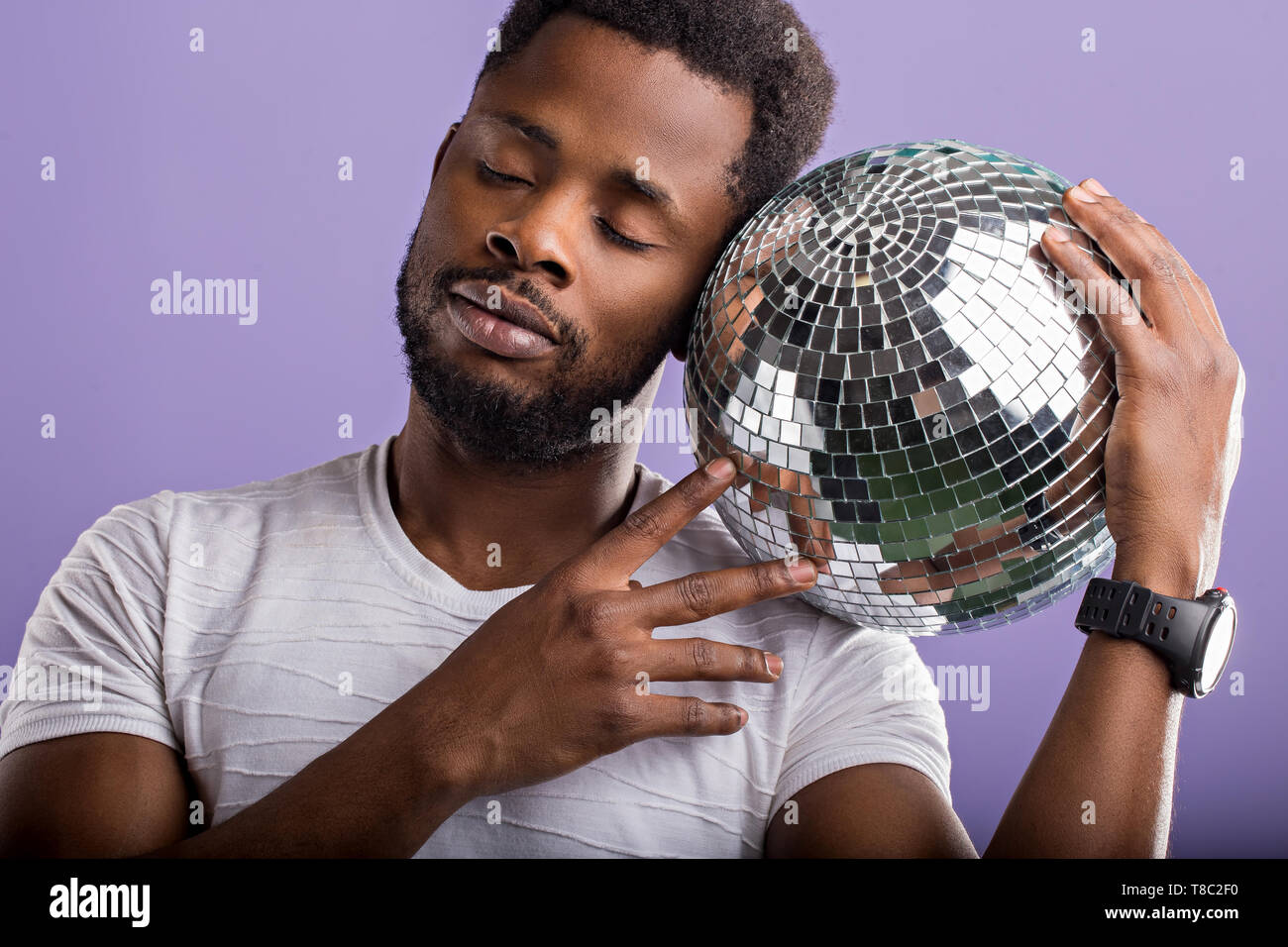 Handsome relaxed unshaven african american man holding shining disco ...