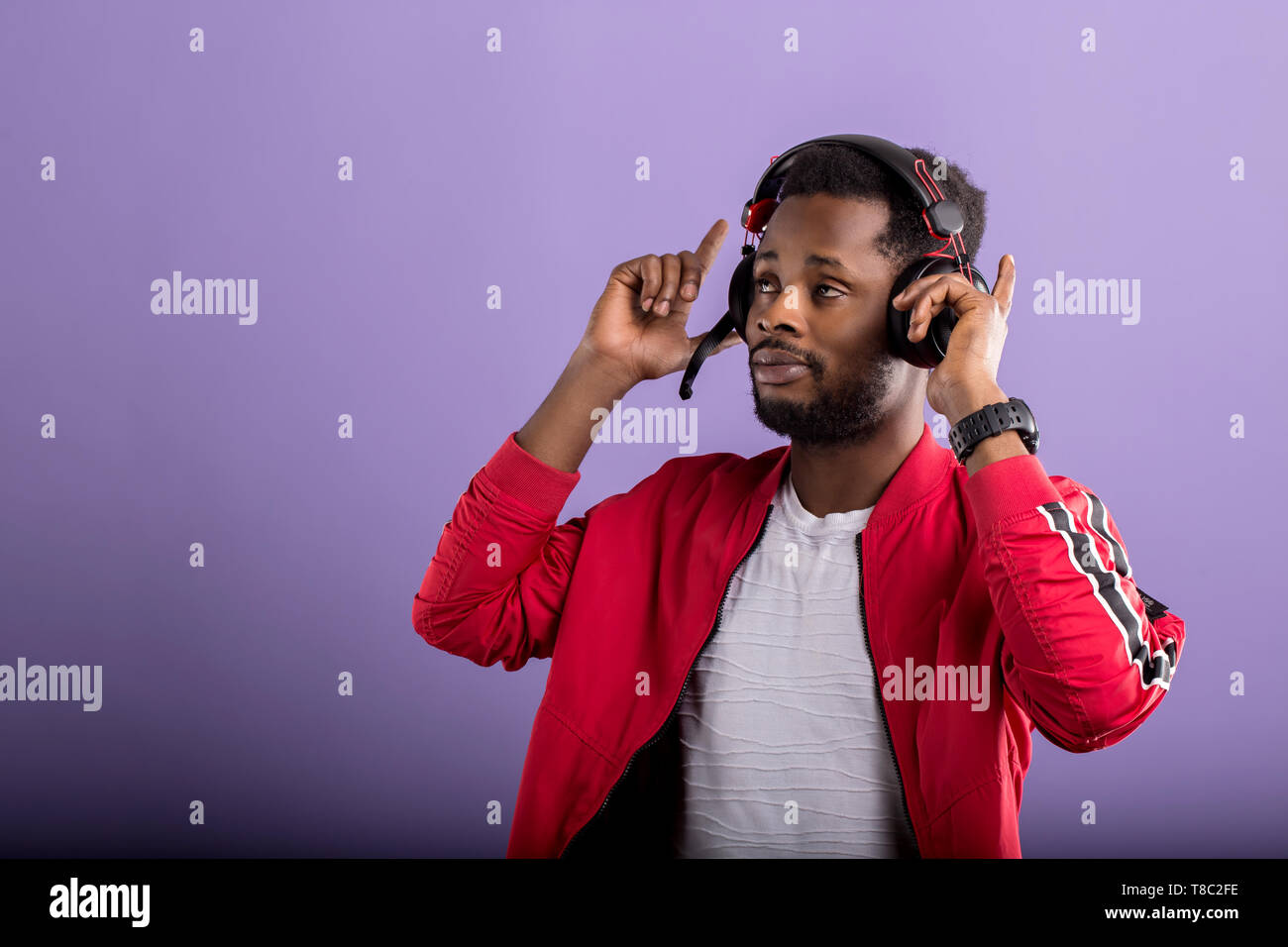 Studio portrait of handsome young black man in headphones, enjoying ...