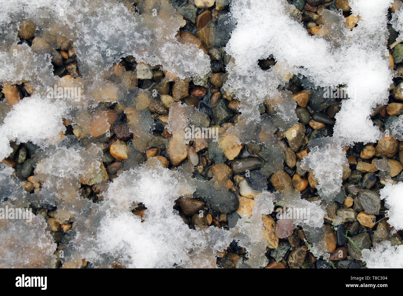 spring snow on the rocks. snow patterns, textured ice Stock Photo - Alamy