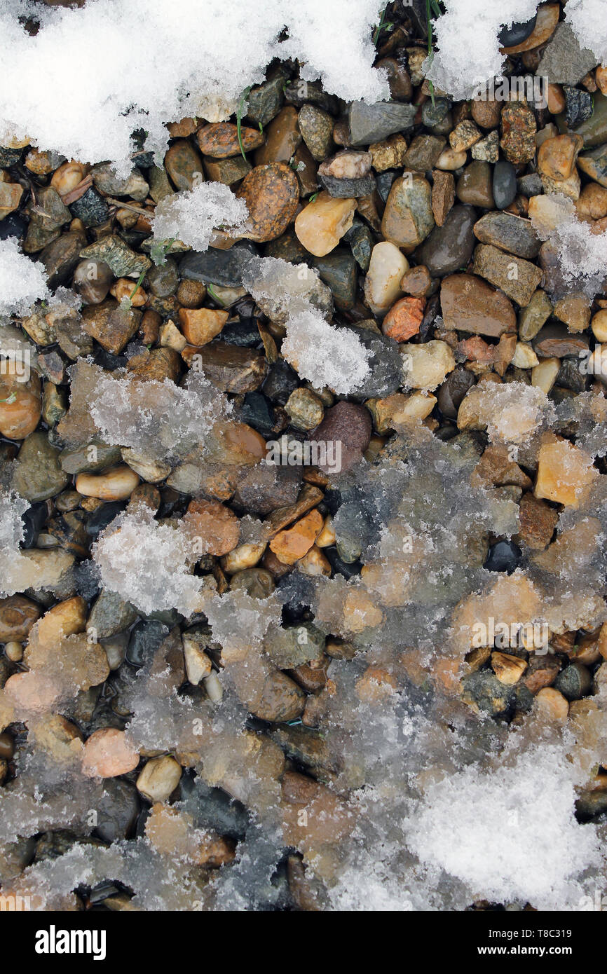 spring snow on the rocks. snow patterns, textured ice Stock Photo - Alamy