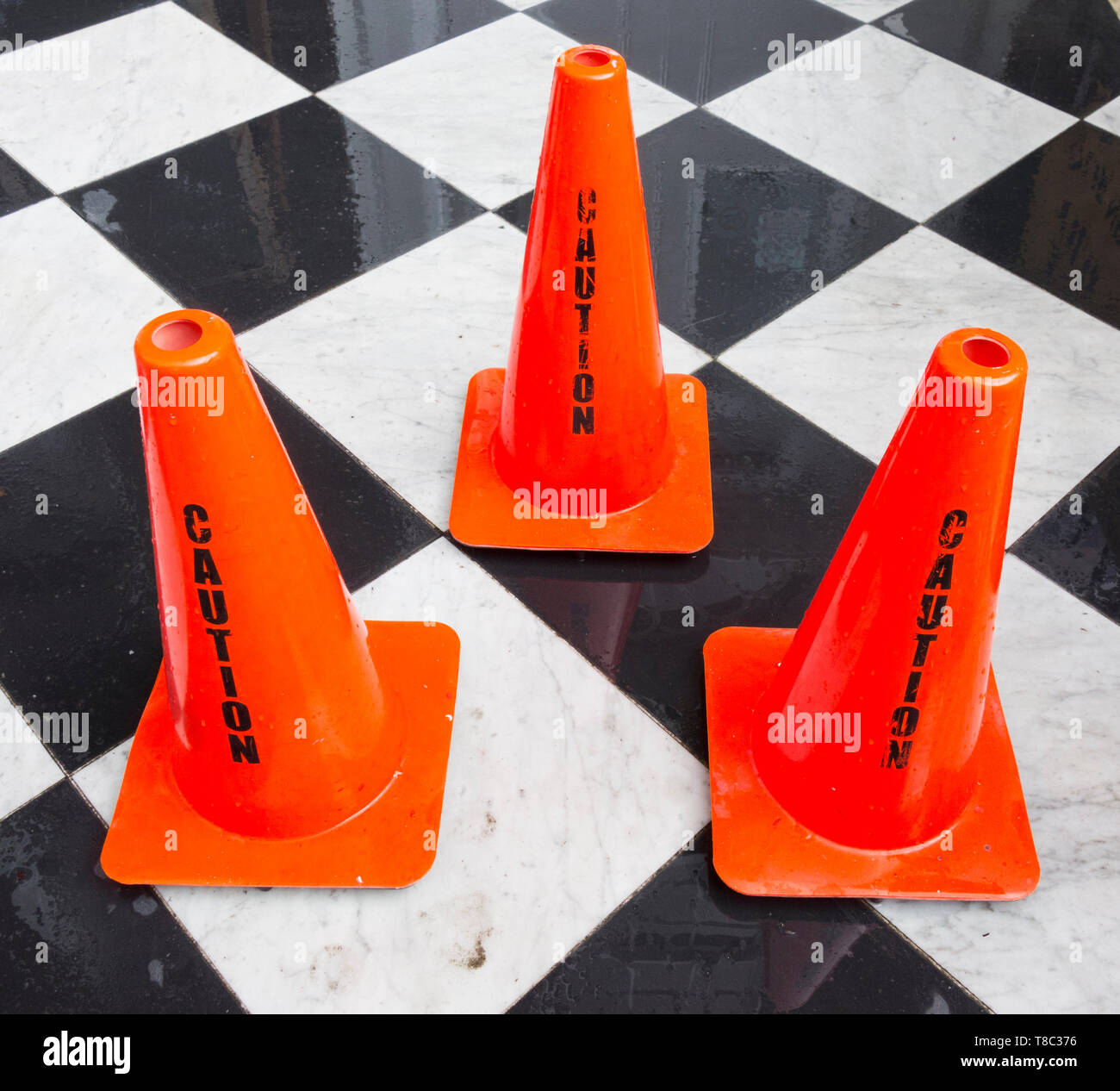 Caution cones on a black and white slippery tiled surface Stock Photo ...