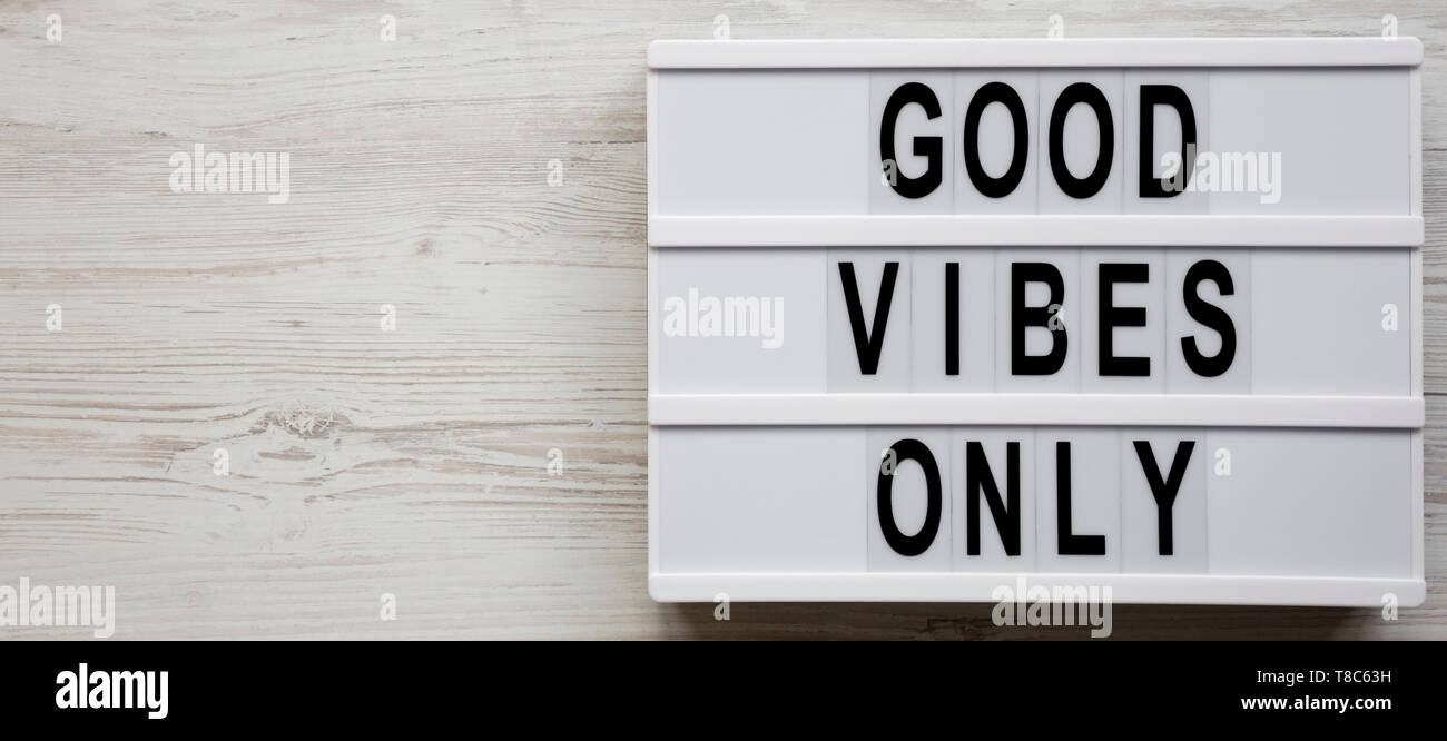 'Good vibes only' words on modern board over white wooden surface, top ...