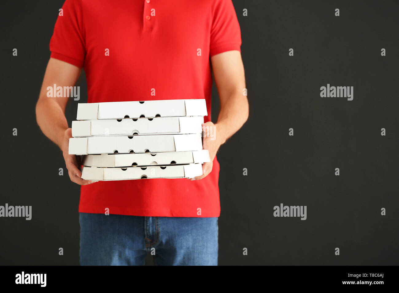 Man with pizza boxes on grey background. Food delivery service Stock ...