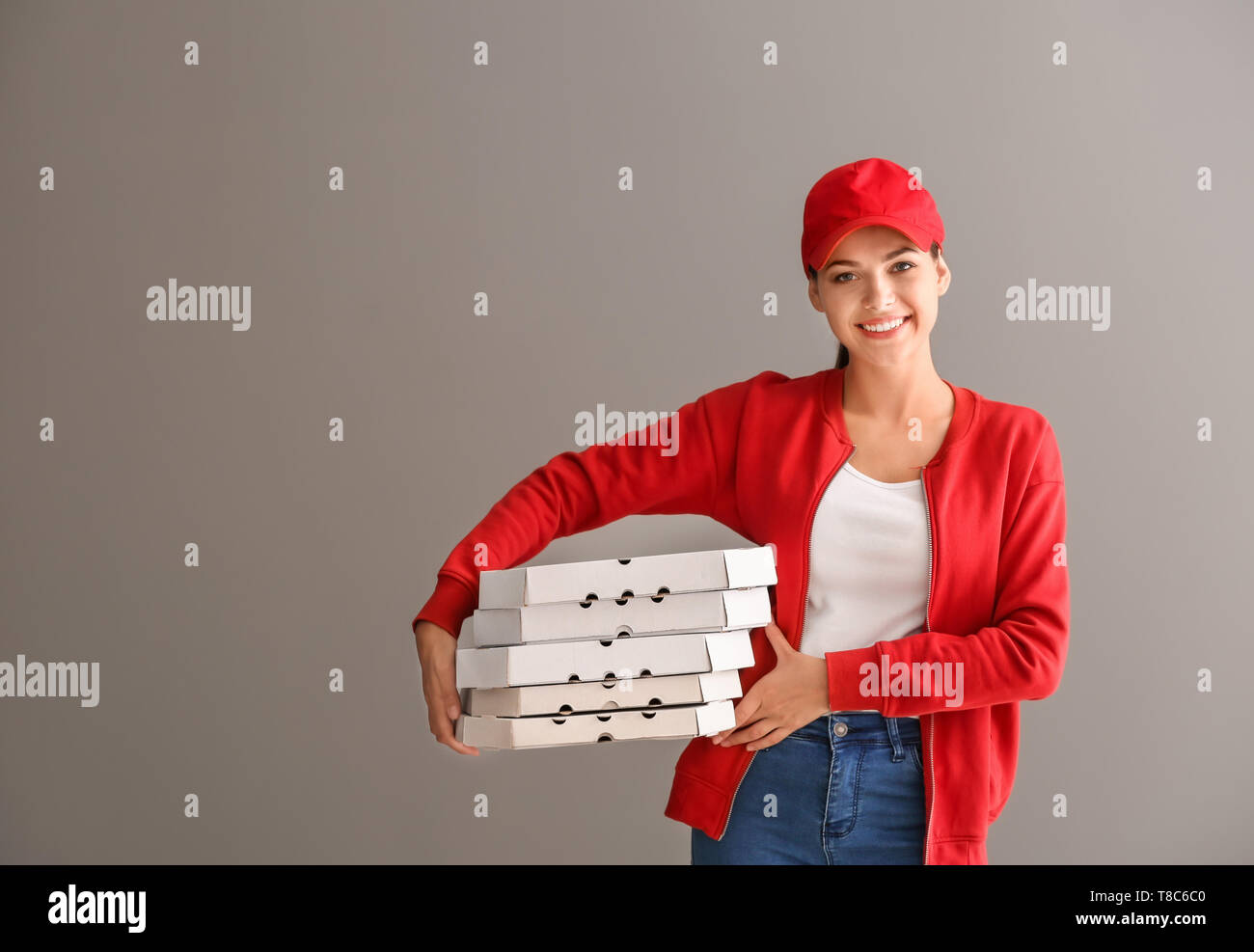 Young woman with pizza boxes on grey background. Food delivery service ...