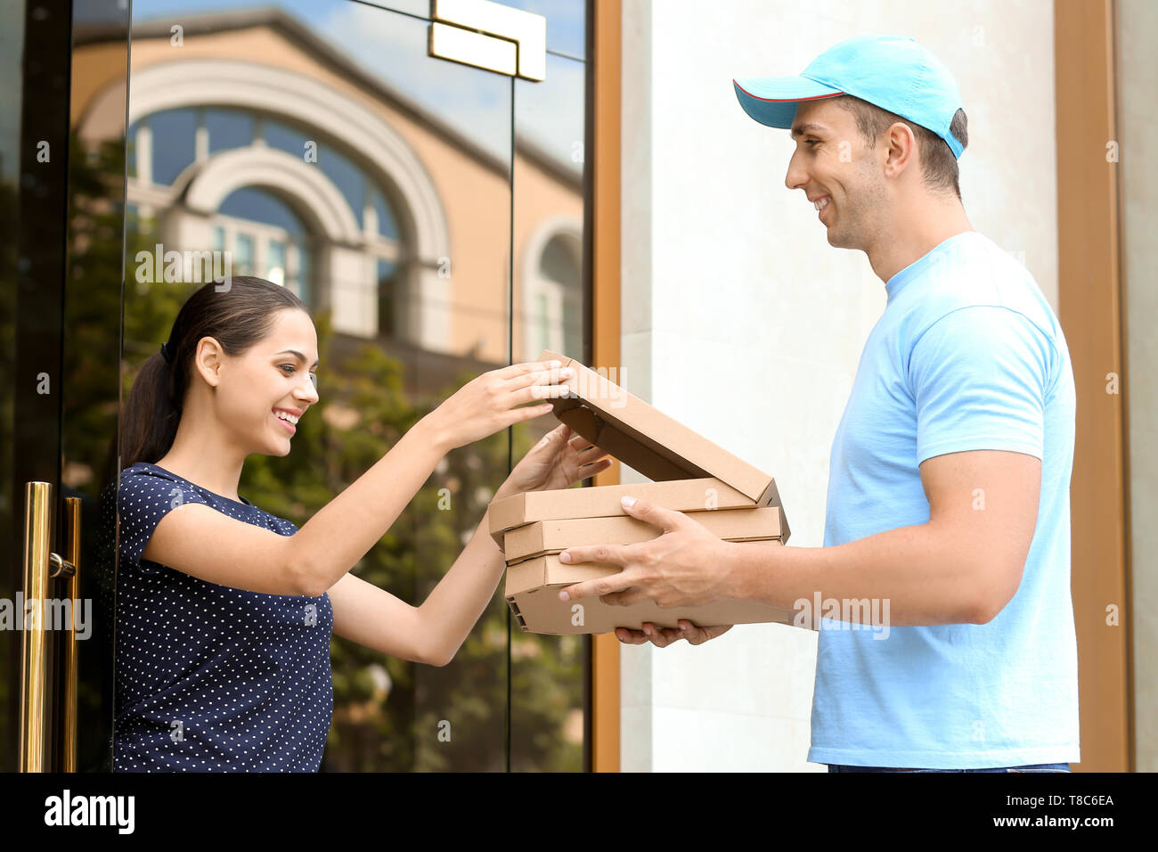 Young man delivering pizza to customer at doorway Stock Photo - Alamy