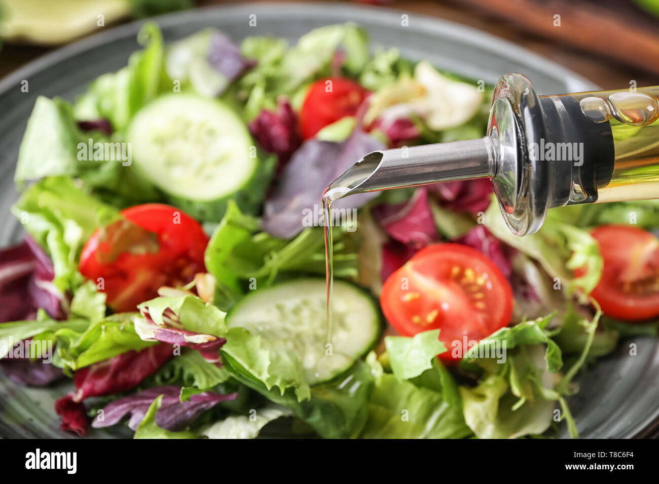 Adding of olive oil to tasty vegetable salad, closeup Stock Photo - Alamy