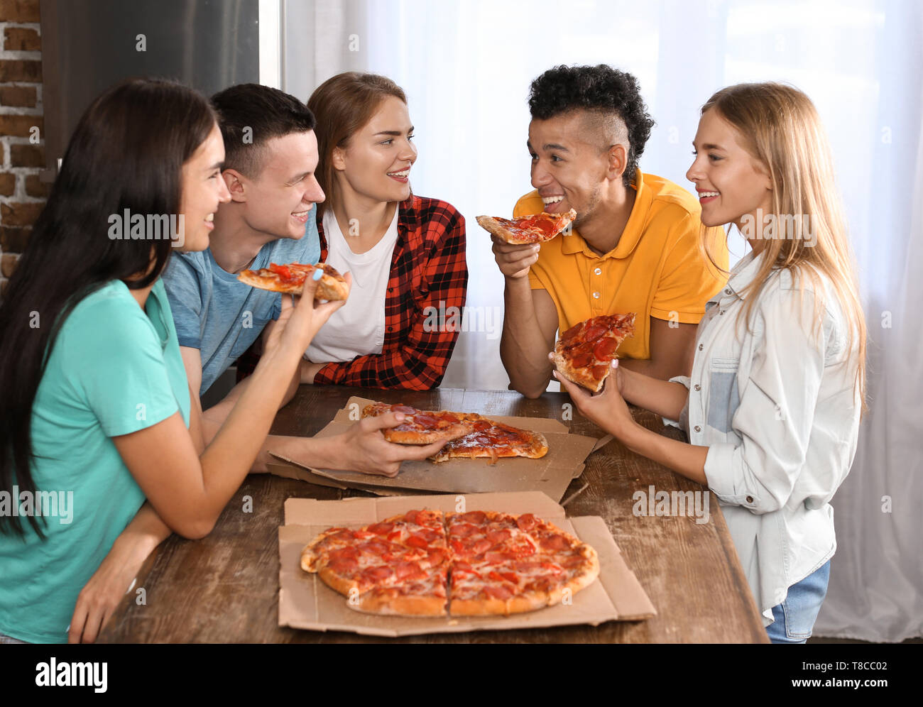 Young people having fun at party with delicious pizza indoors Stock ...