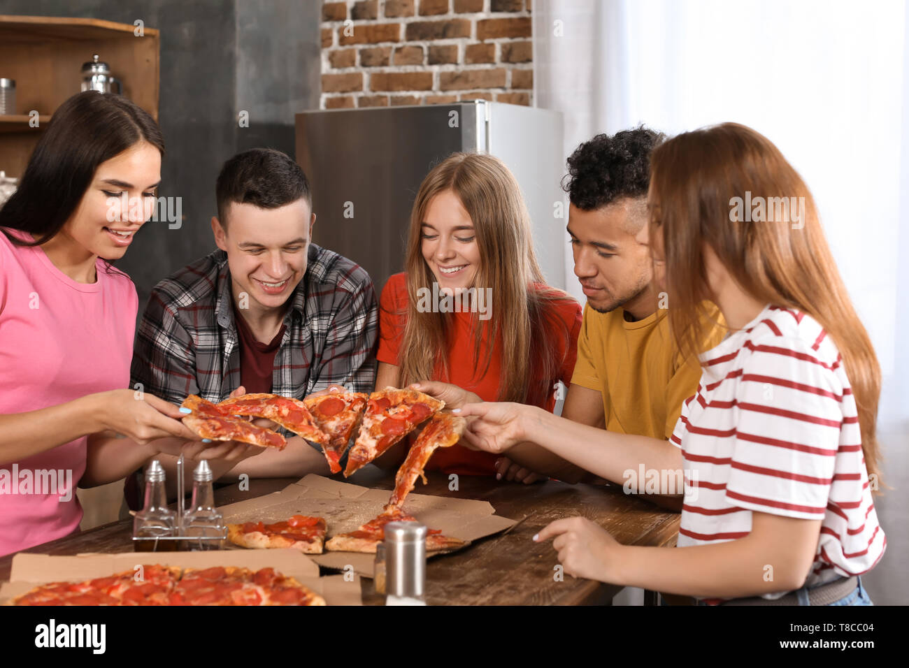 Young people having fun at party with delicious pizza indoors Stock ...