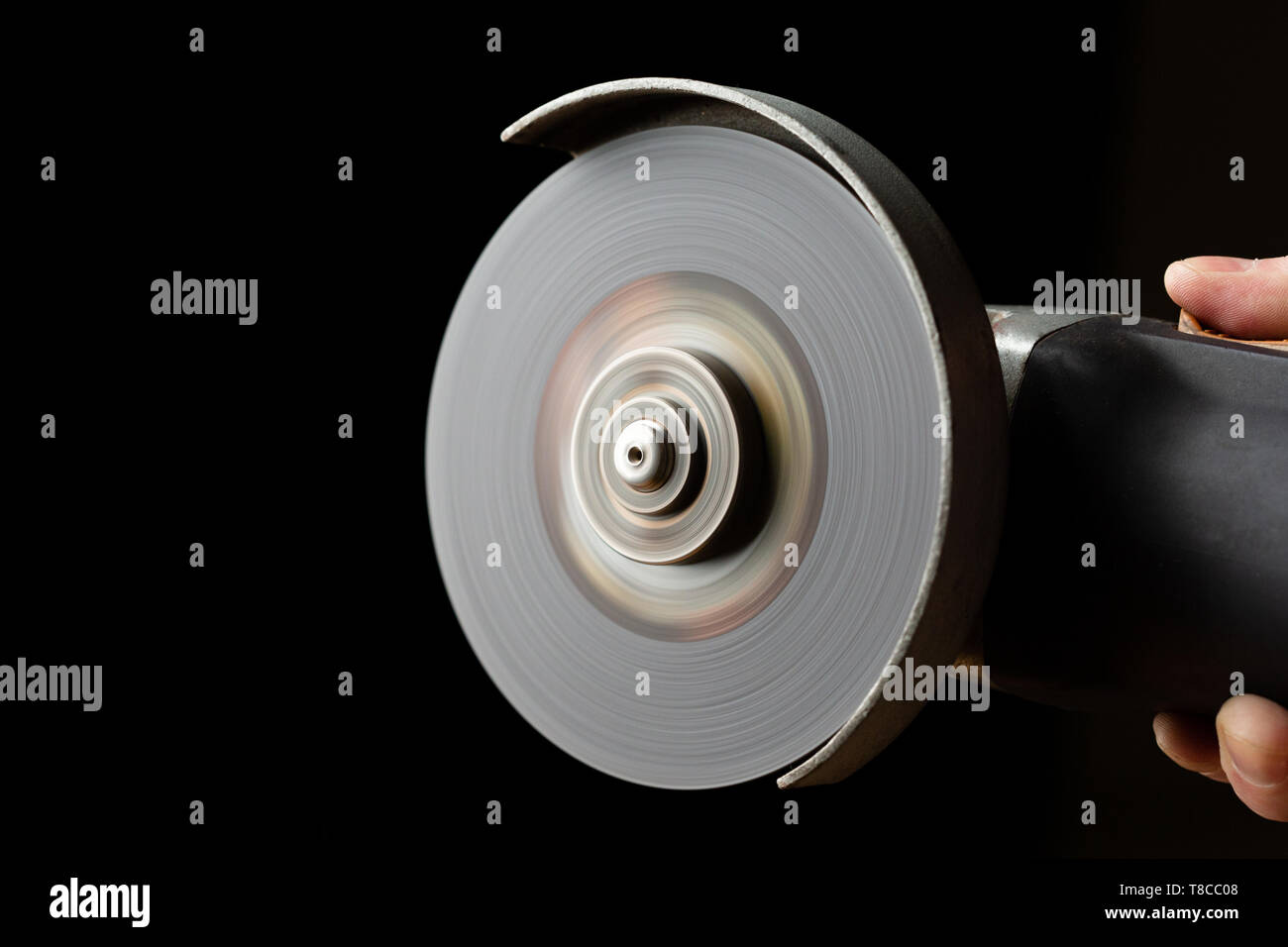 In the hand of a working grinding machine with a cutting wheel on a ...