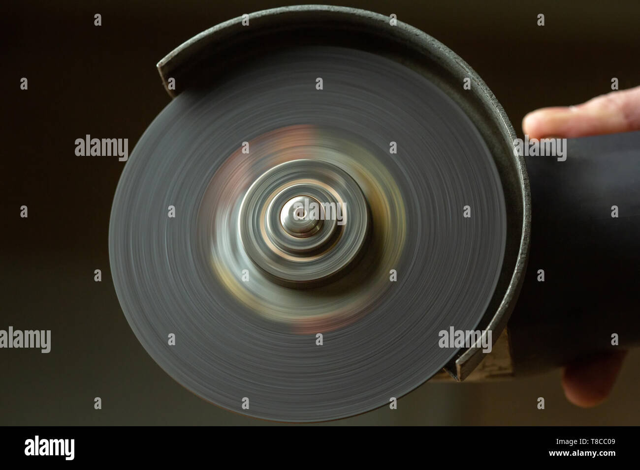 In the hand of a working grinding machine with a cutting wheel on a ...