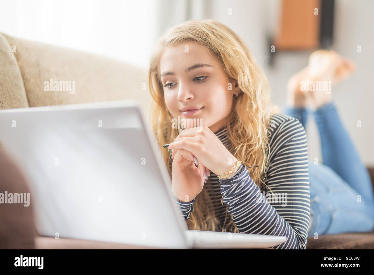 Beautiful young girl using laptop computer in living room Stock Photo ...