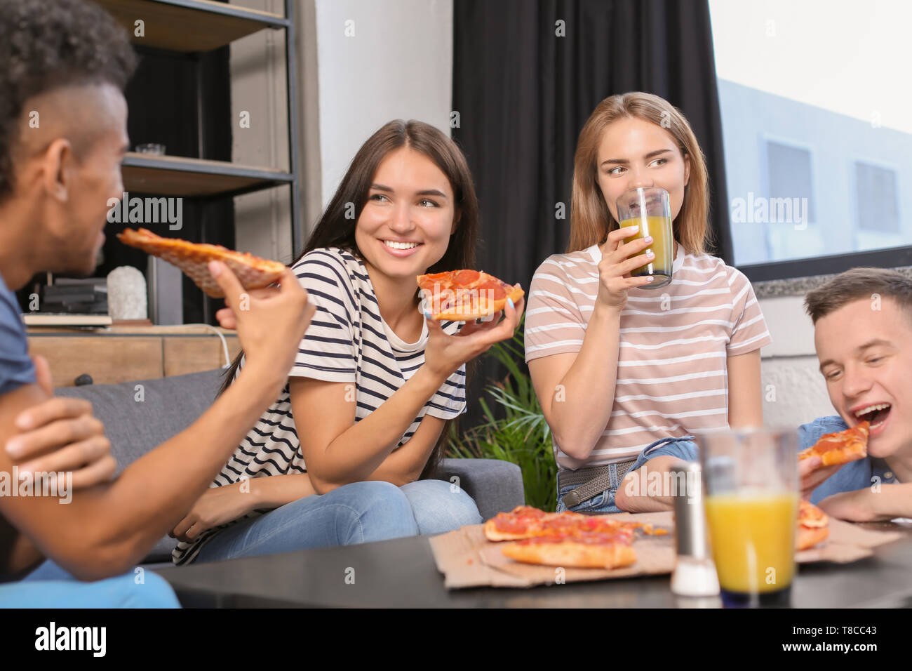 Young people having fun at party with delicious pizza indoors Stock ...