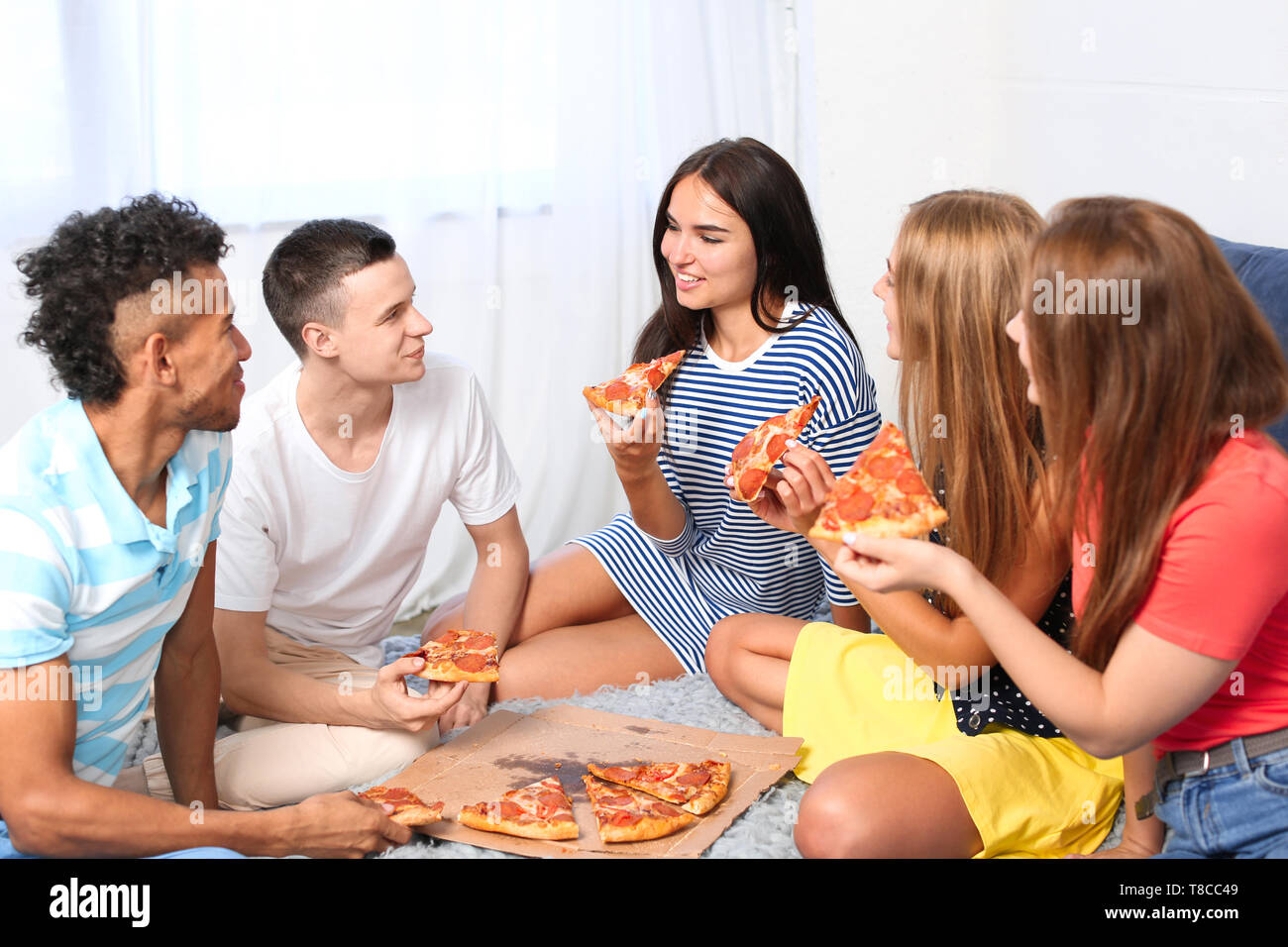 Young people having fun at party with delicious pizza indoors Stock ...