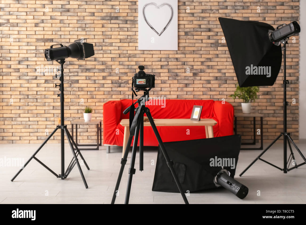 Interior of modern photo studio with sofa and professional equipment ...