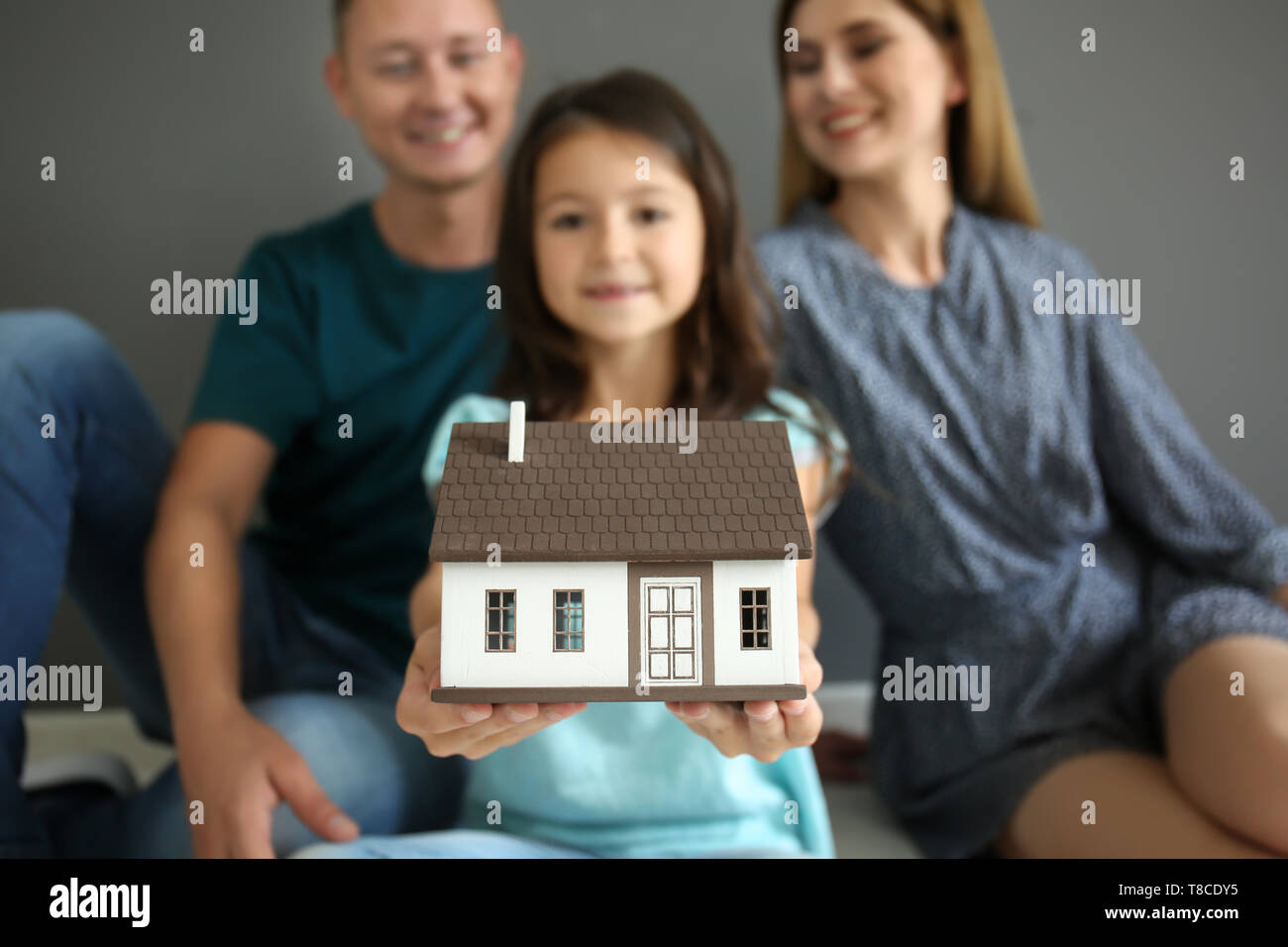 Happy family with house model indoors. Moving into new house Stock ...
