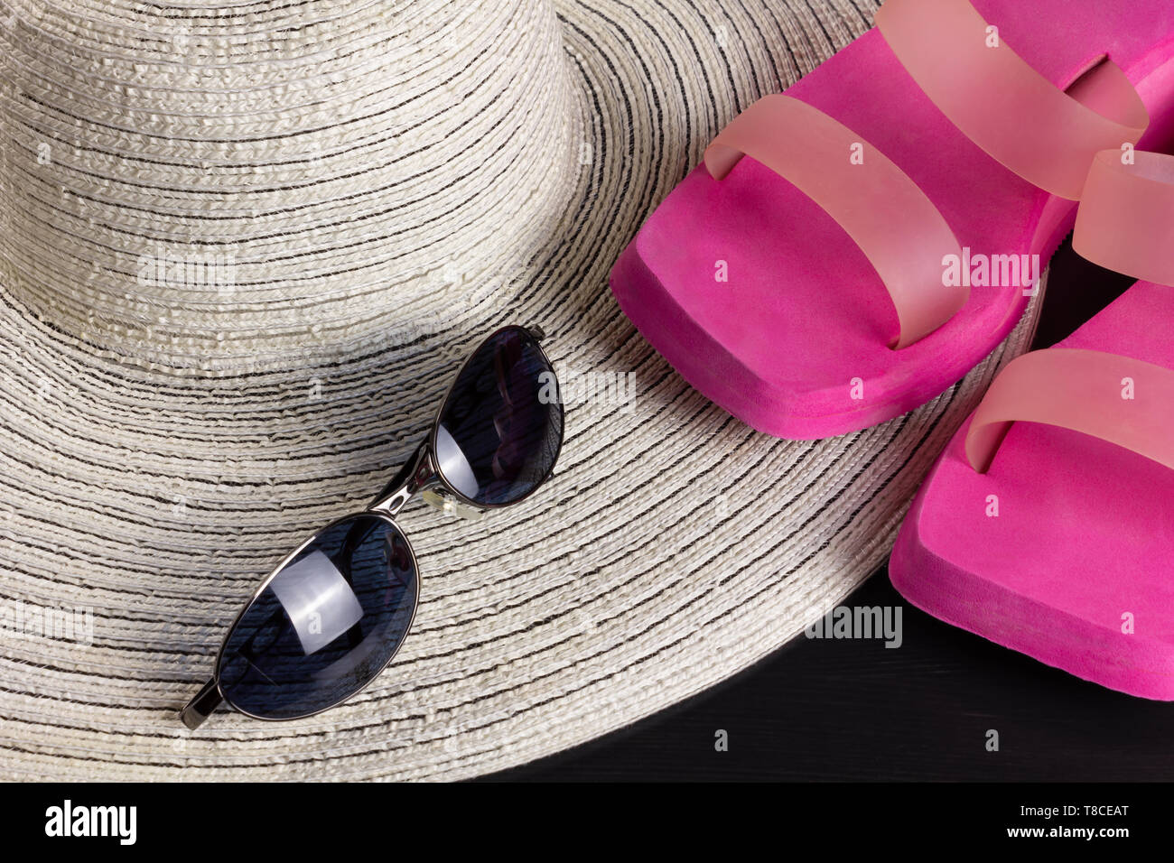 White straw hat, purple beach sandals and a pair of blue shaded ...