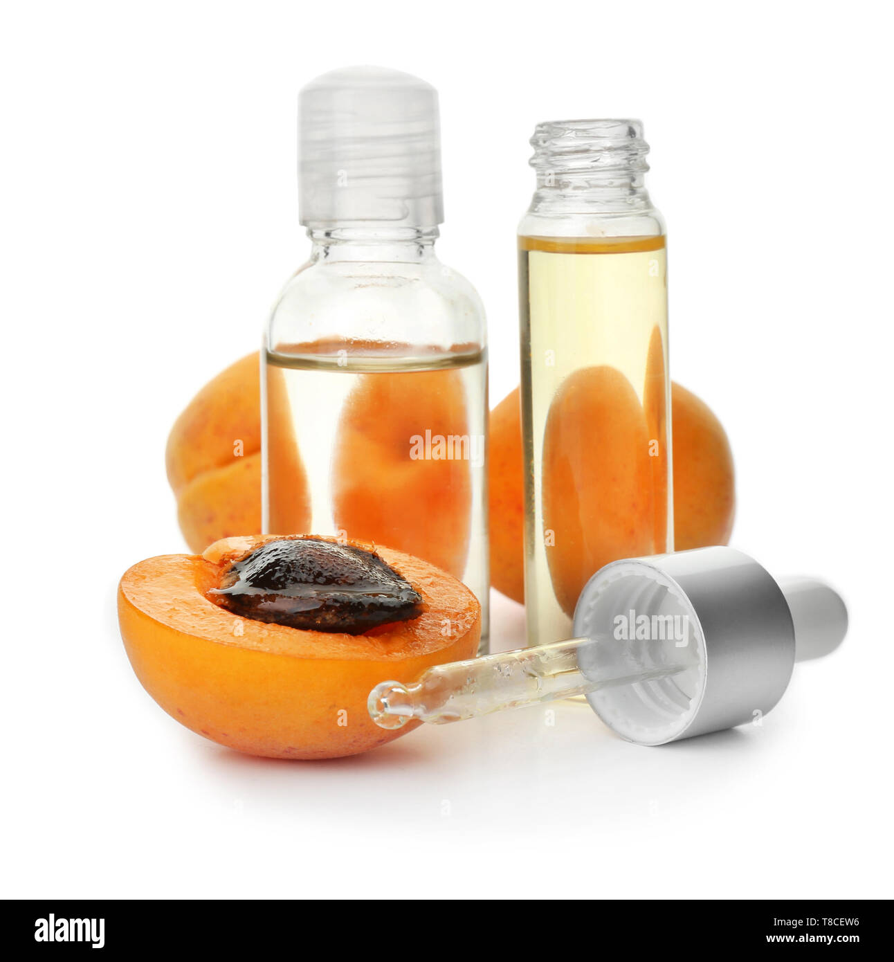 Bottles of apricot essential oil on white background Stock Photo - Alamy