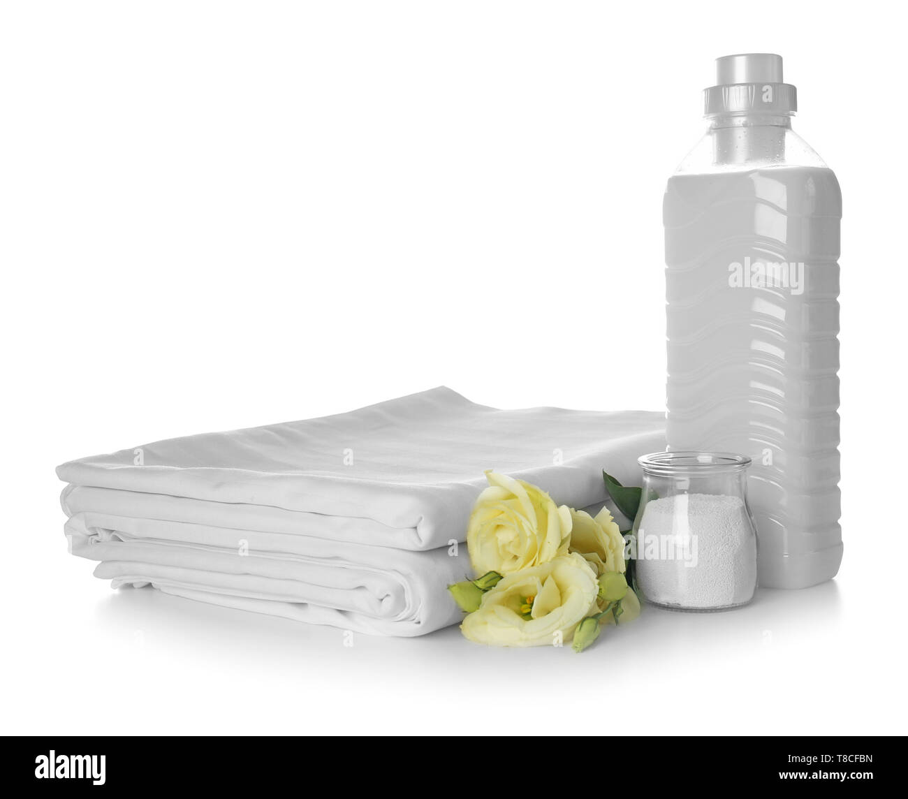 Stack of clean bed sheets and washing detergents on white background ...