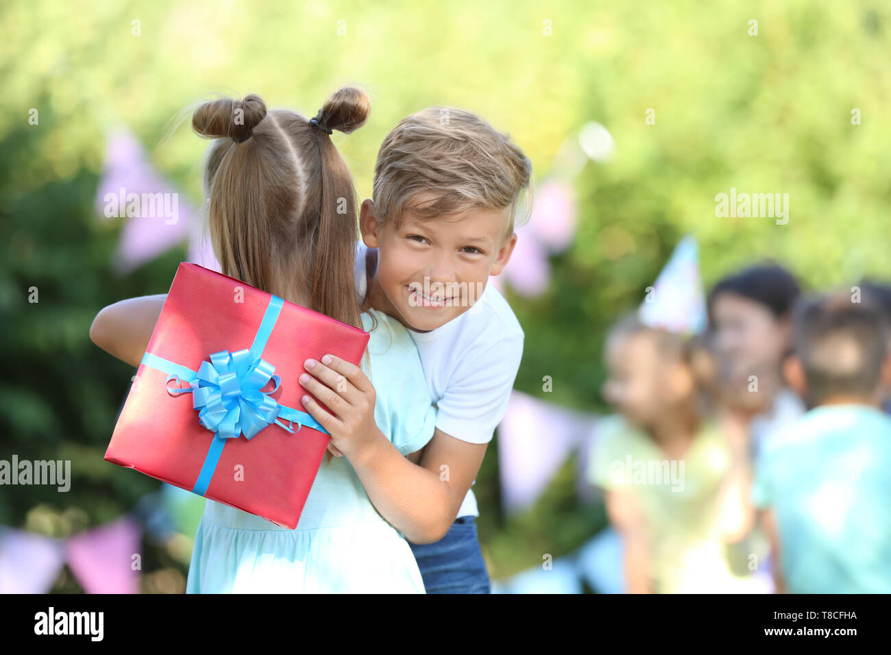 Cute little boy receiving Birthday gift from his friend outdoors Stock ...