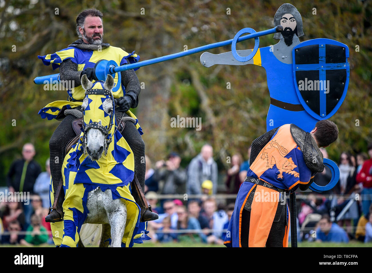 The blue knight spears a hoop with his lance during a jousting ...