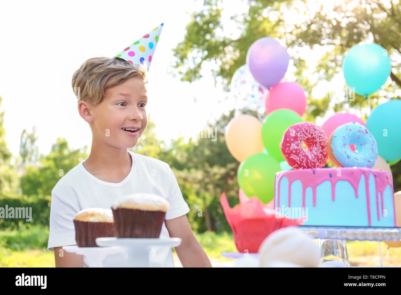 Emotional little boy with cake celebrating Birthday outdoors Stock ...