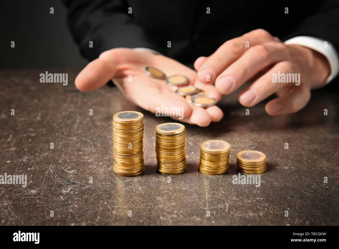 Man counting coins at table. Savings concept Stock Photo - Alamy