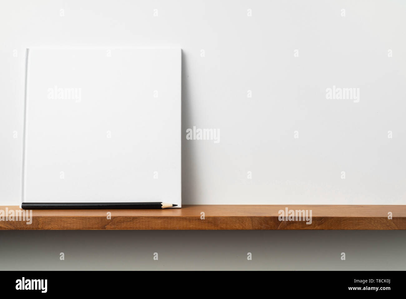 Design concept - front view of square white notebook on bookshelf and ...
