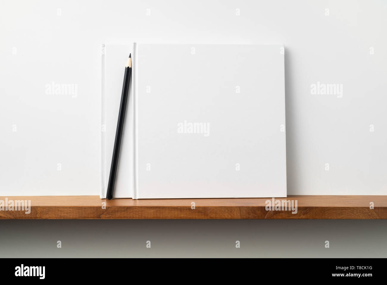 Design concept - front view of 2 square white notebook on bookshelf and ...