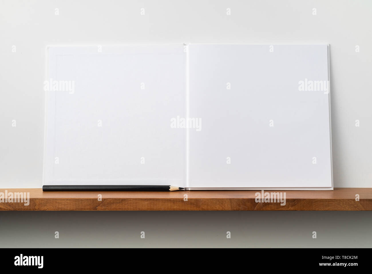 Design concept - front view of square white notebook on bookshelf and ...