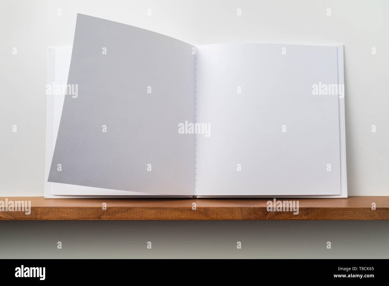 Design concept - front view of open square white notebook on bookshelf ...