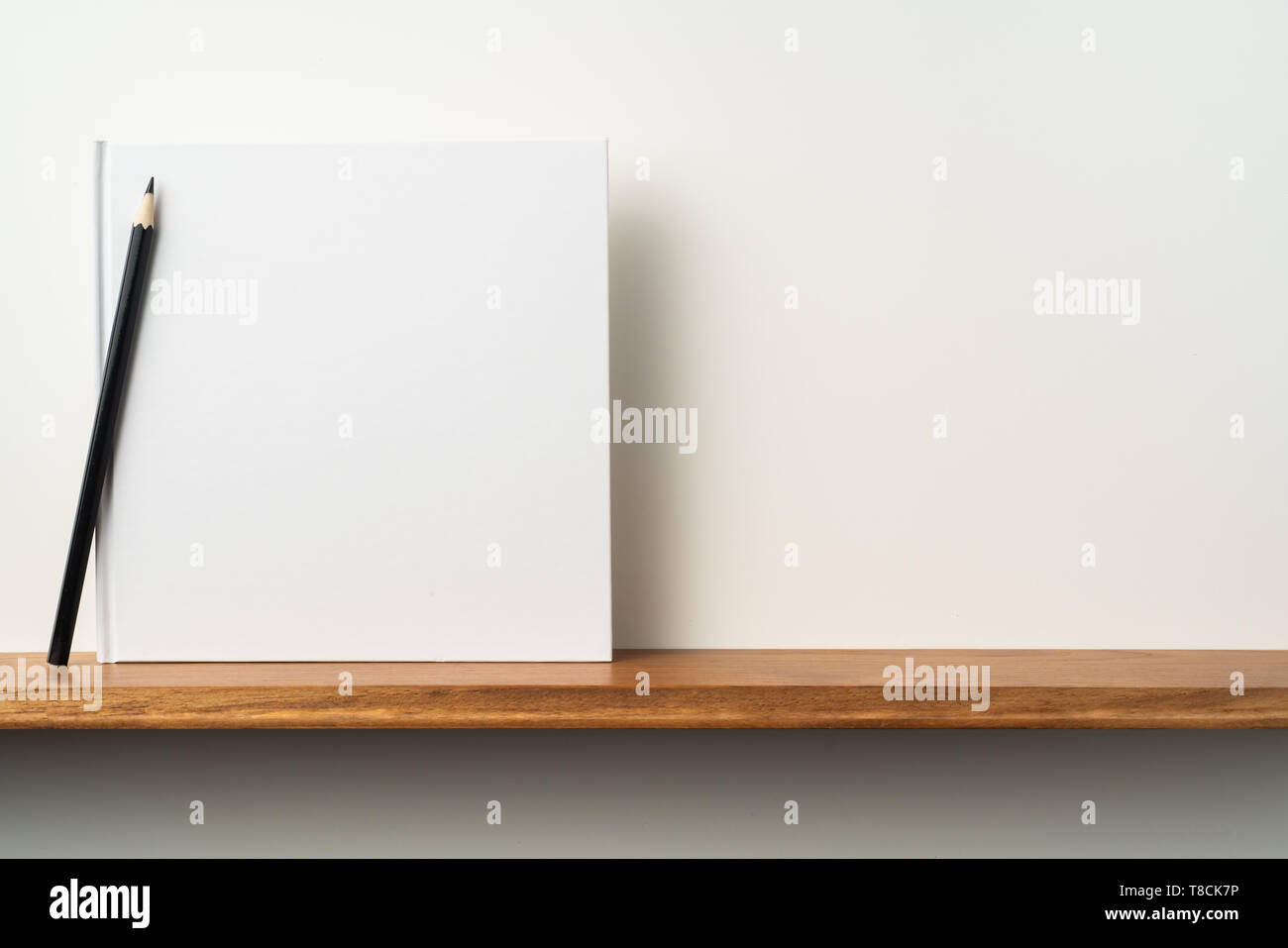 Design concept - front view of square white notebook on bookshelf and ...