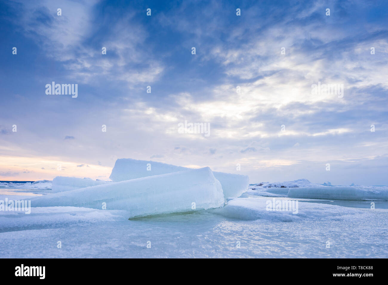 Beach in wintertime. Frozen sea, evening light and icy weather on shore ...