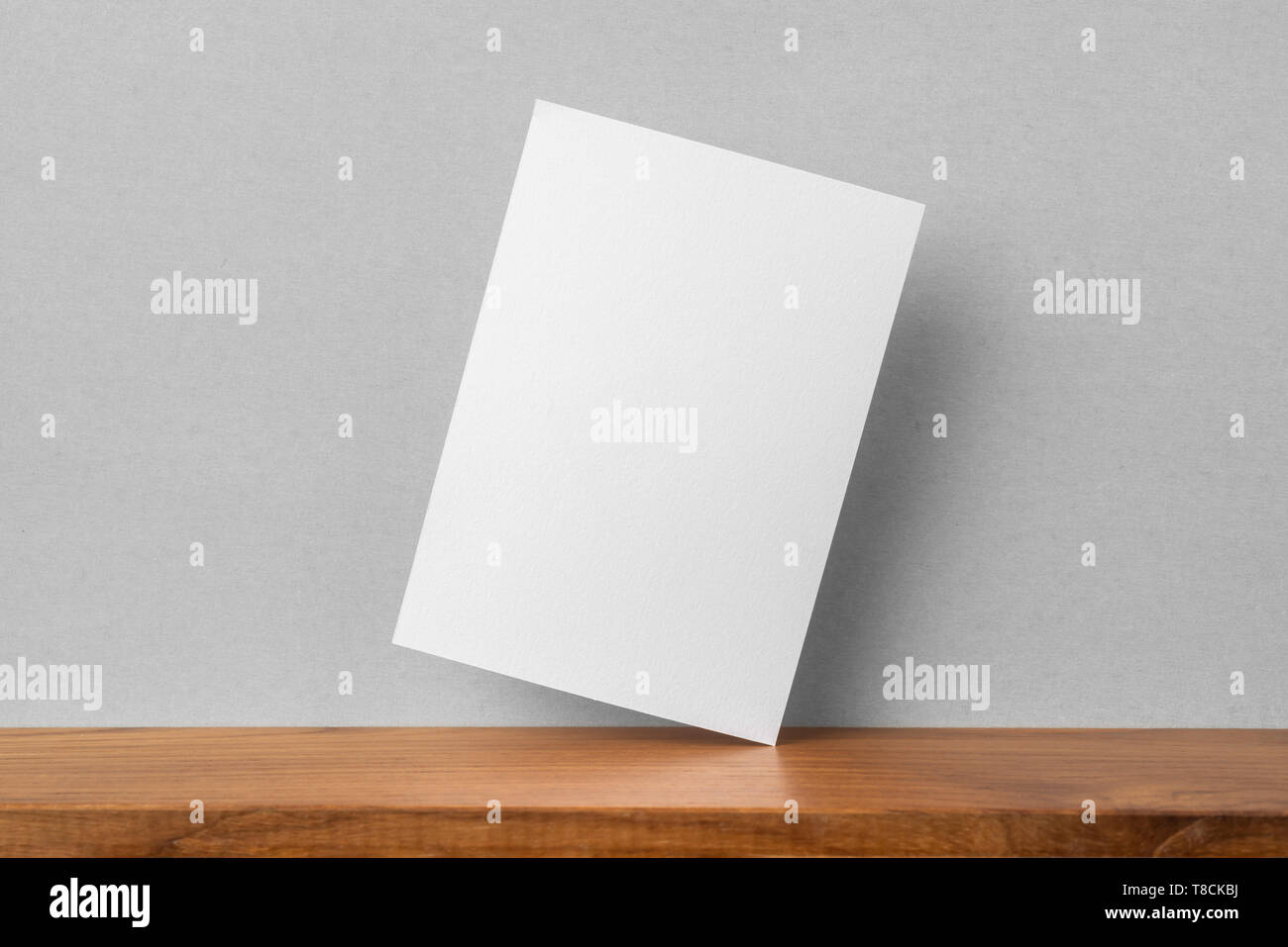 Design concept - front view of A4 paper on bookshelf and grey wall for ...